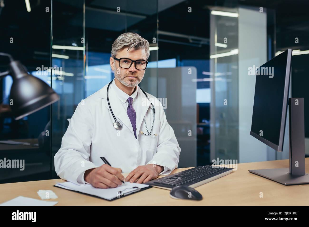 Portrait of an experienced doctor with glasses, a senior and ...