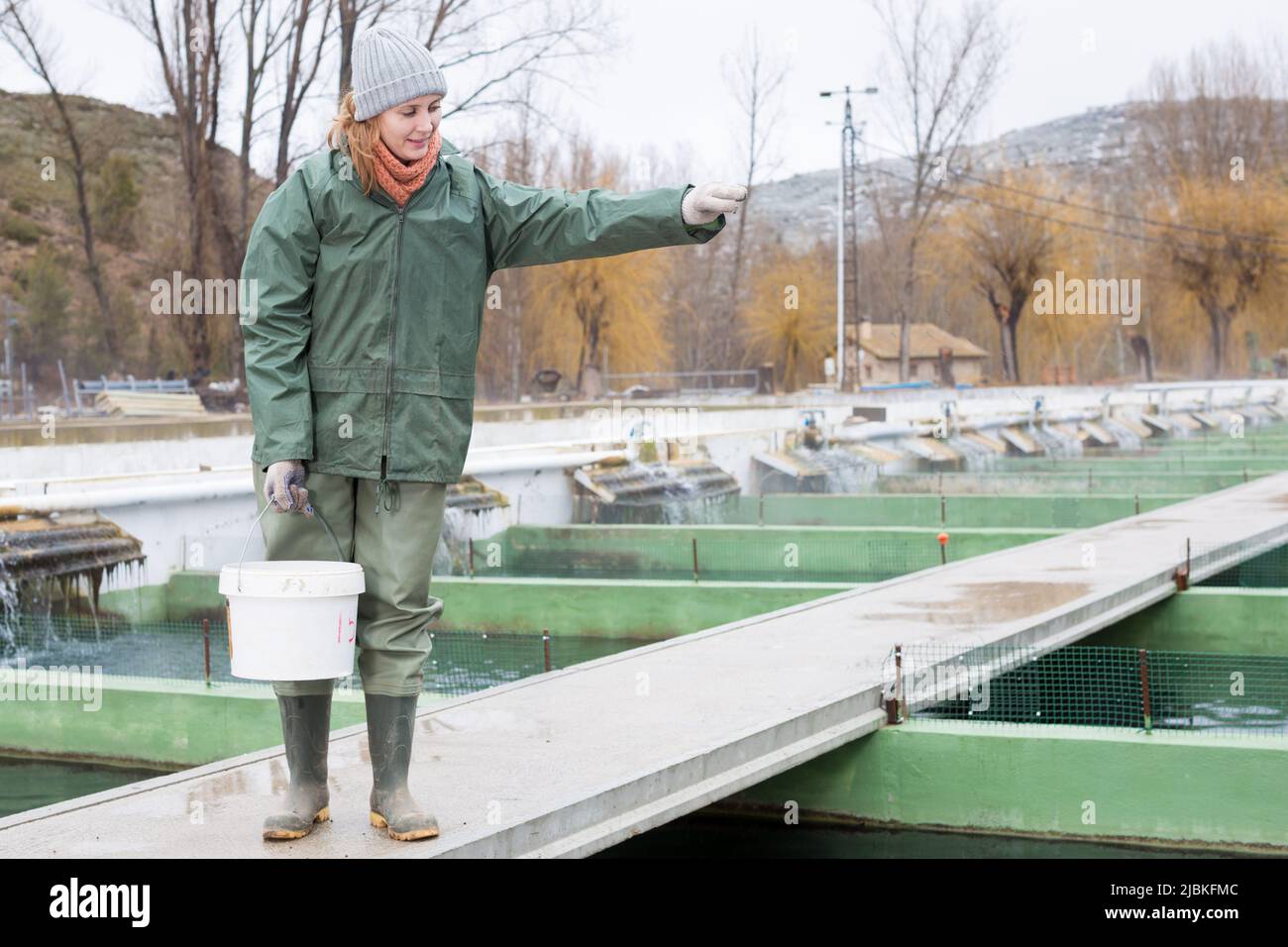 Female owner on sturgeon farm feeding fish Stock Photo - Alamy