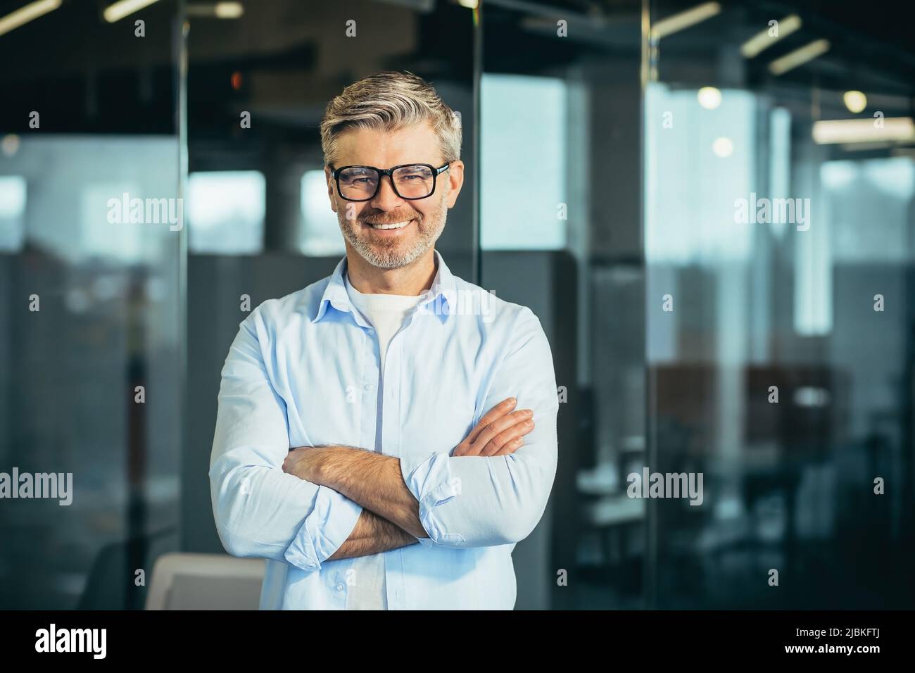 Portrait of senior and experienced male boss boss, with arms crossed ...