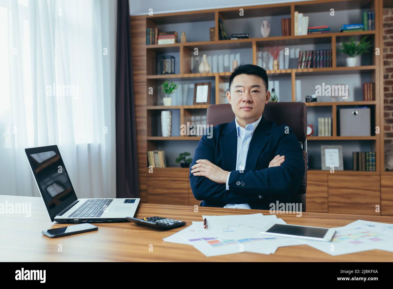 Portrait of a young handsome Asian man, businessman, boss in a suit ...