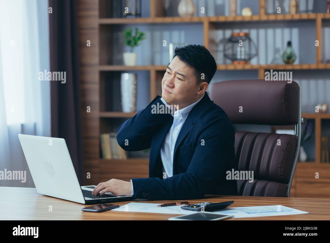 Tired young asian businessman man, worker holding his neck, feeling ...