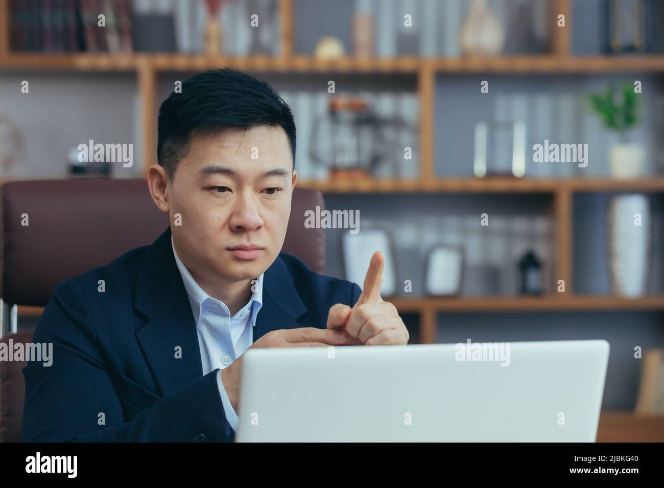 Asian businessman boss talking to colleagues on video call, looking at ...