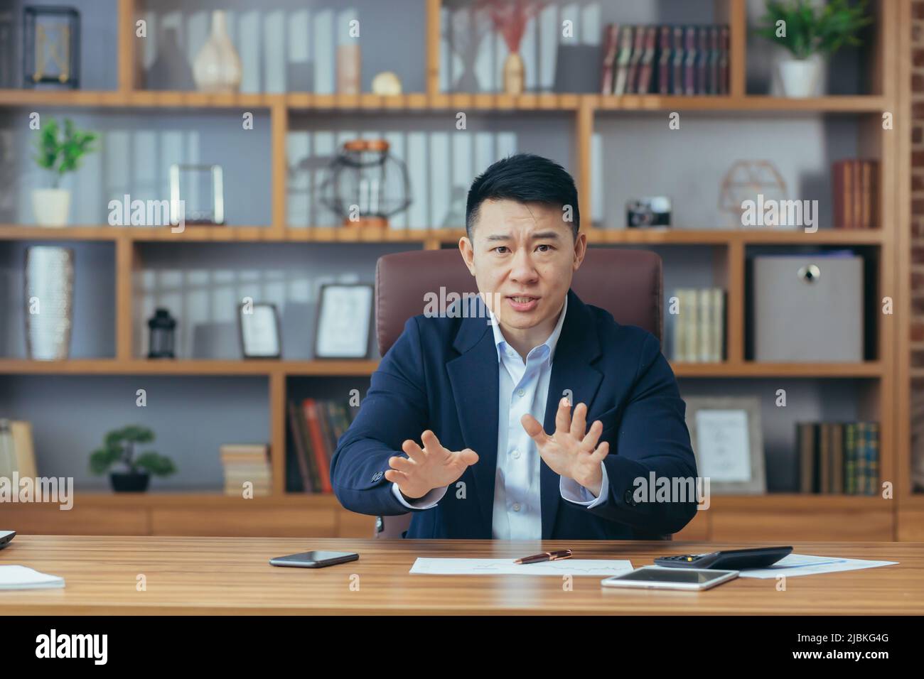 Serious and angry businessman boss looking at camera talking on video ...