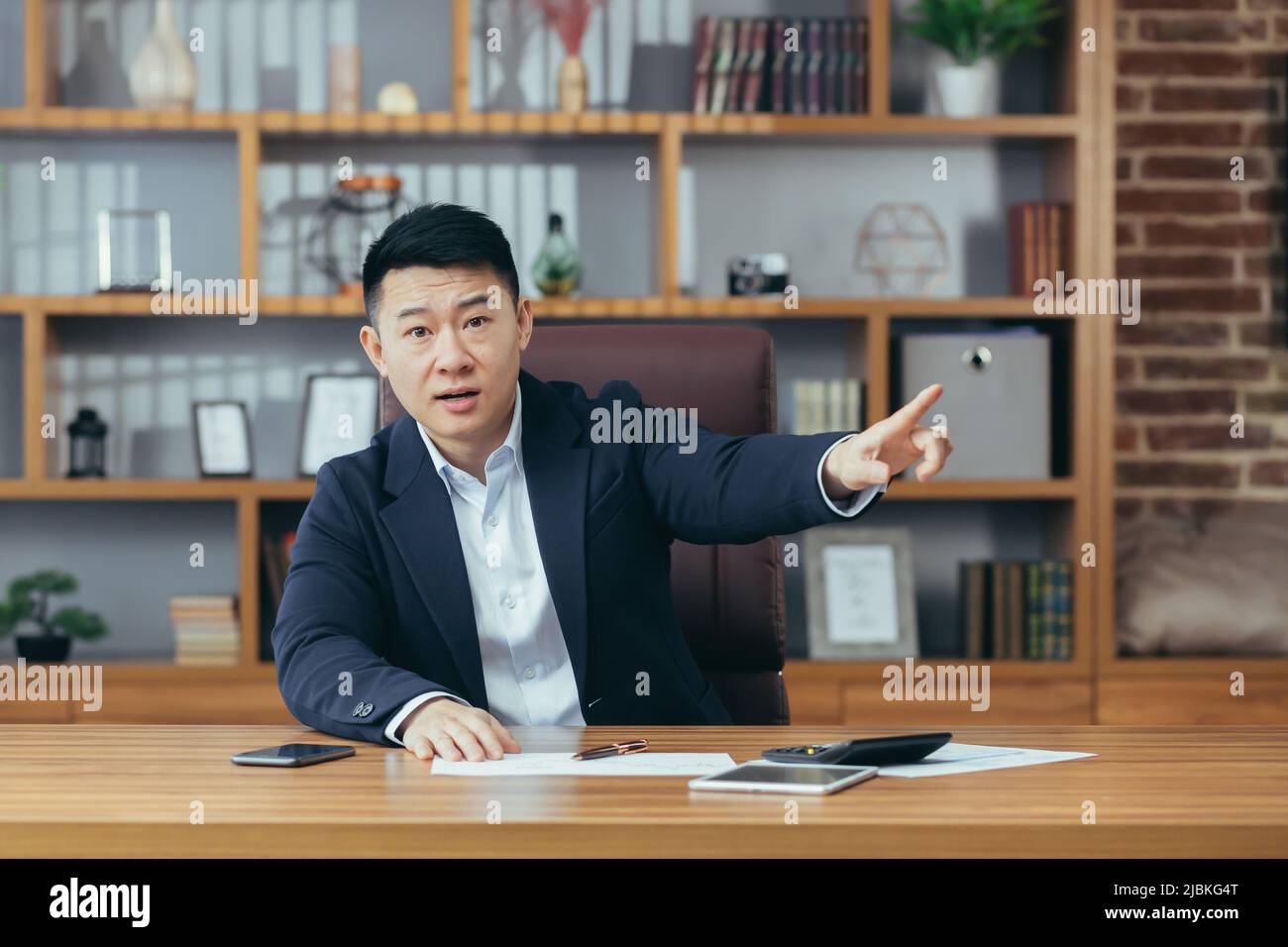 Asian angry businessman, boss fires employee looking at camera and ...