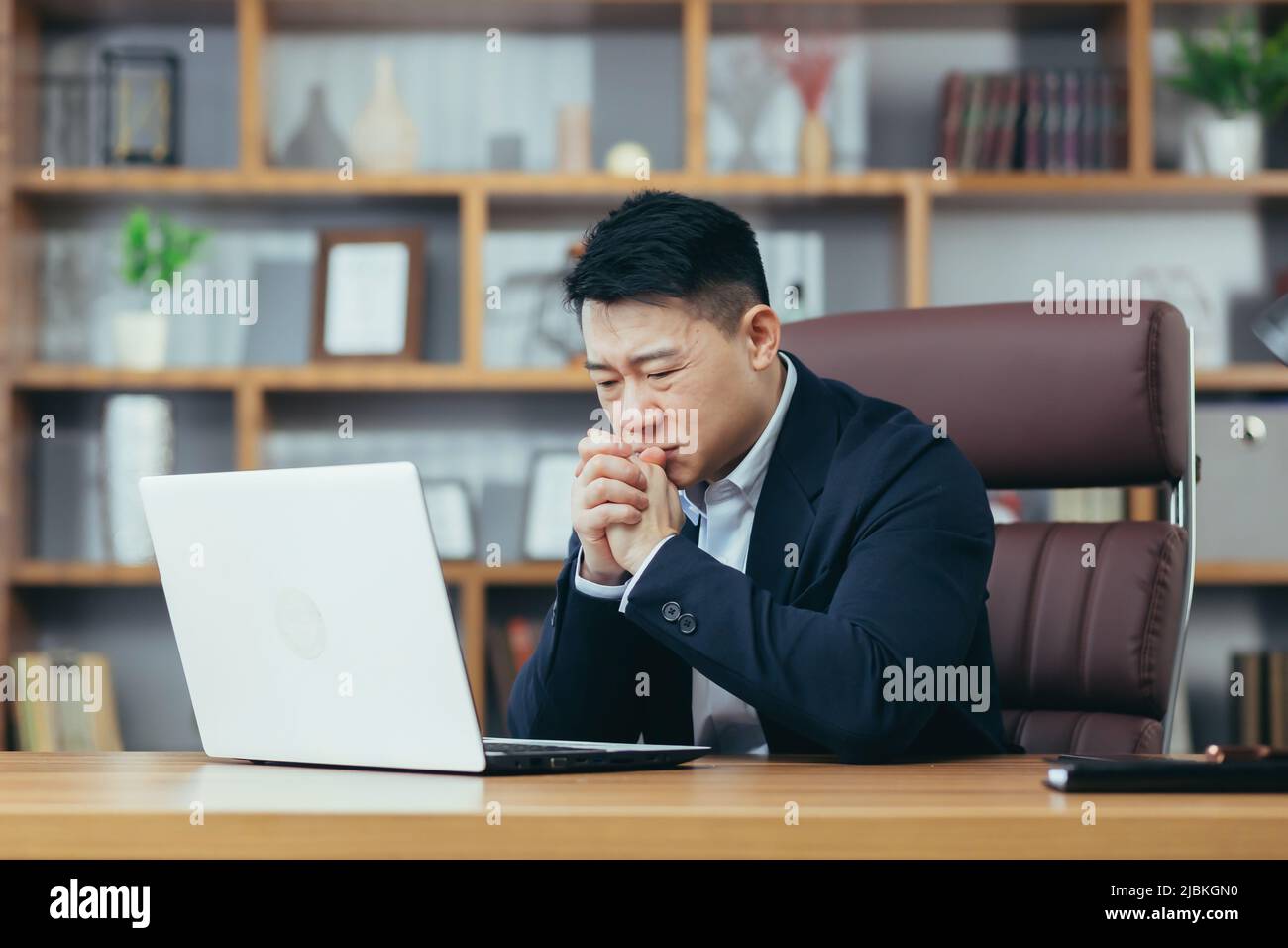 Man thinking working on laptop, Asian in classic office, boss working ...