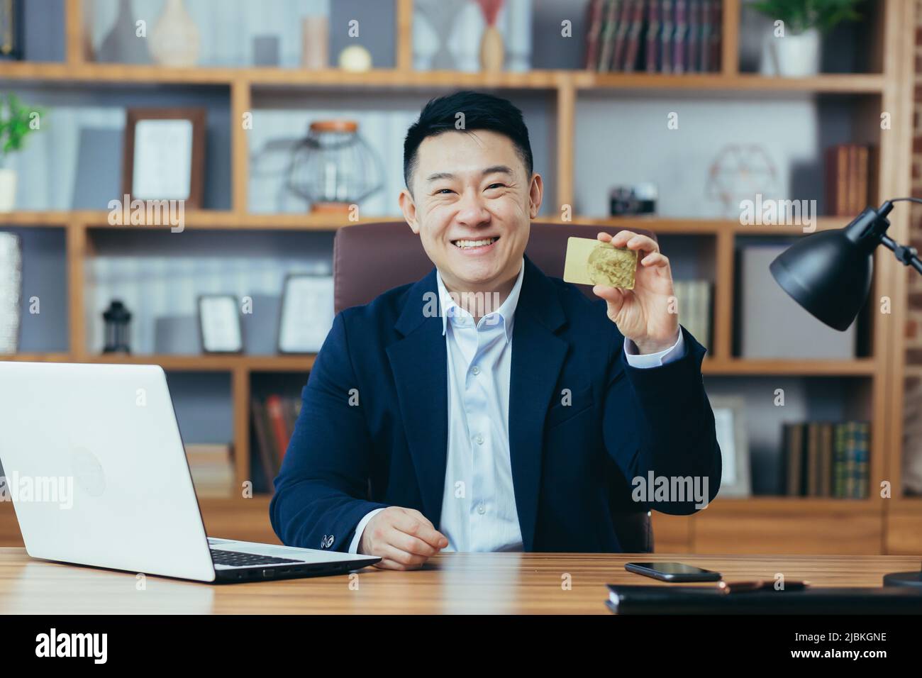 Happy and exciting asian banking businessman looking at camera and ...