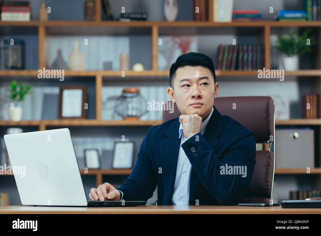 Man thinking working on laptop, Asian in classic office, boss working ...
