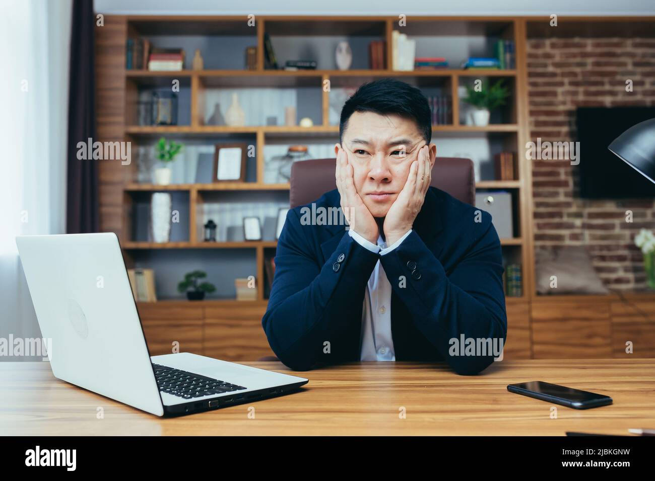 Man thinking working on laptop, Asian in classic office, boss working ...