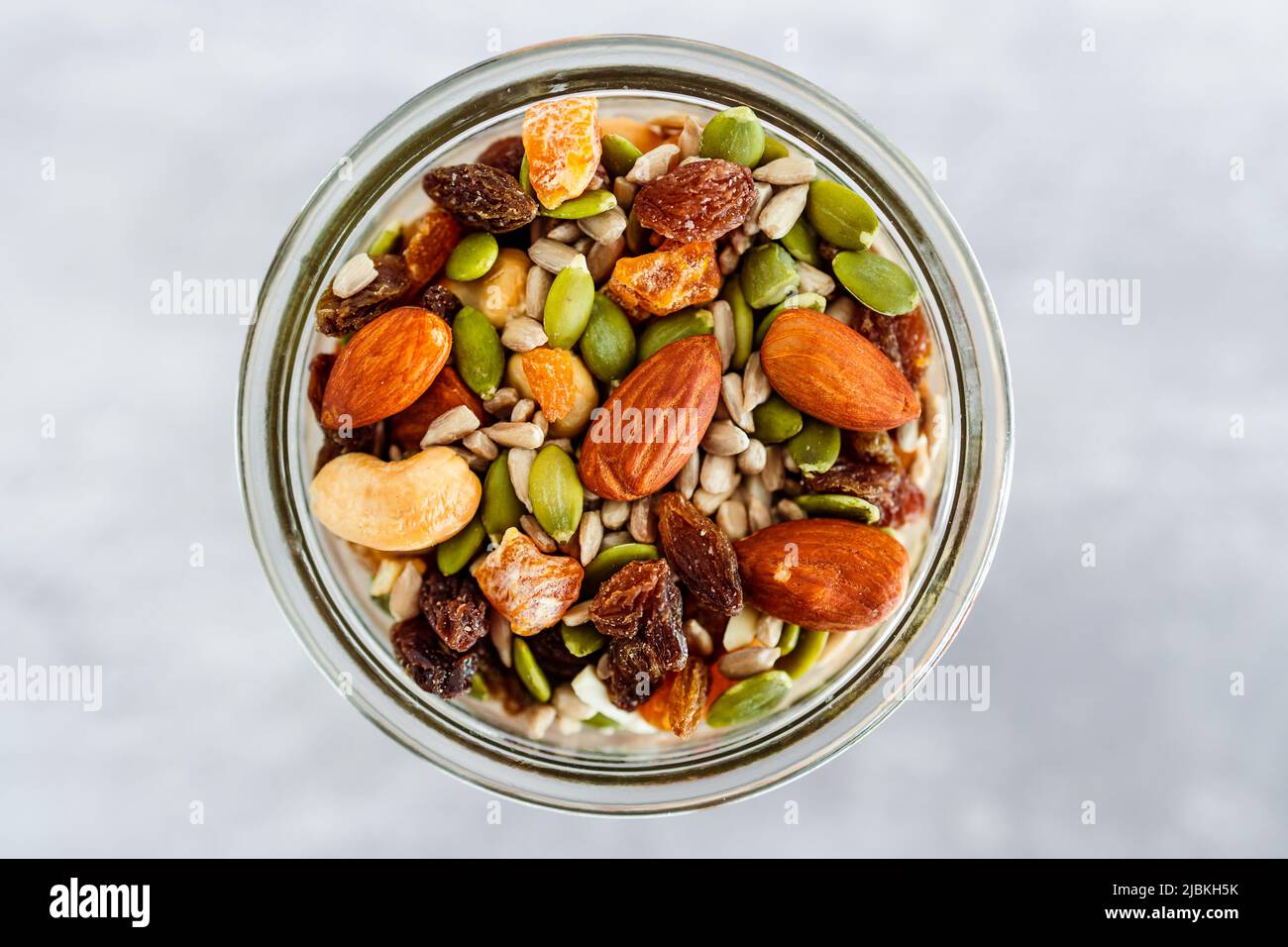 glass jar of mixed nuts including almonds cashews and pistachios, concept of natural healthy ...
