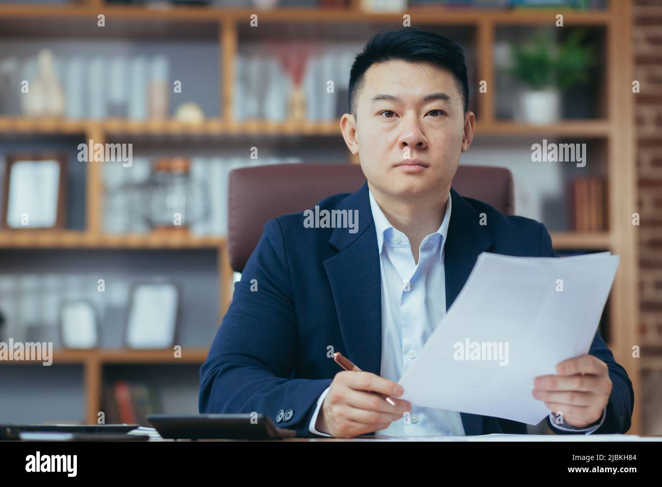 Asian man signing documents looking hi-res stock photography and images ...