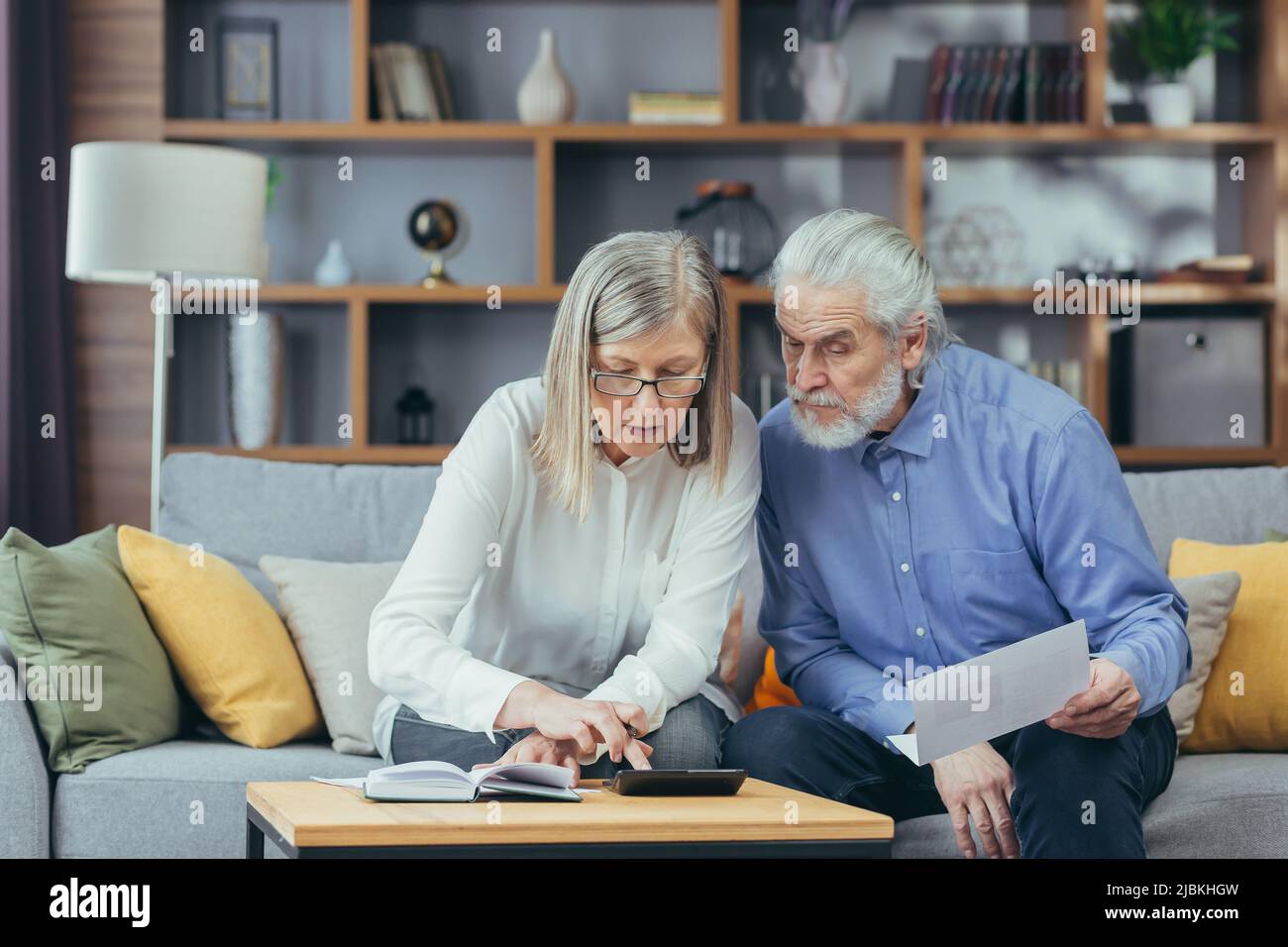 gray hair mature senior couple counting money and calculating finances ...