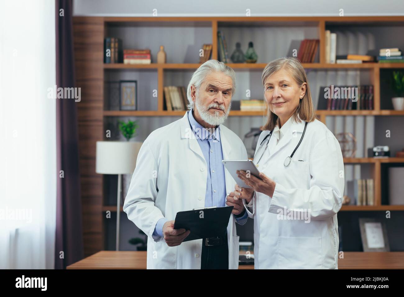 Gray-haired fellow doctors, male and female doctors work together in a ...
