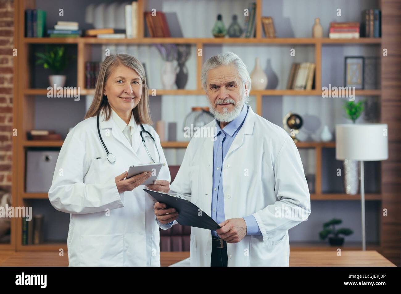 Gray-haired fellow doctors, male and female doctors work together in a ...