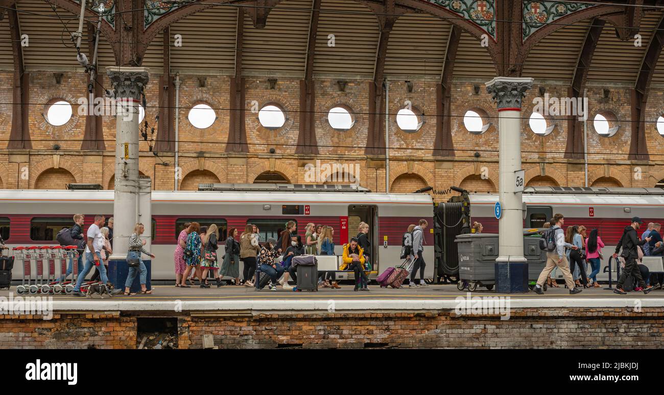 Passengers walk along a railway station platform after alighting from a ...