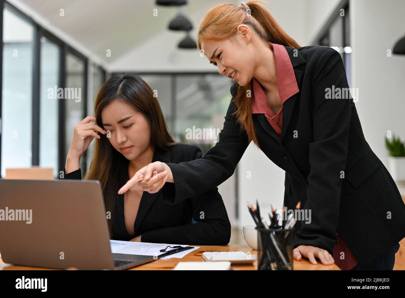 An angry female boss is complaining to her assistant about her work ...