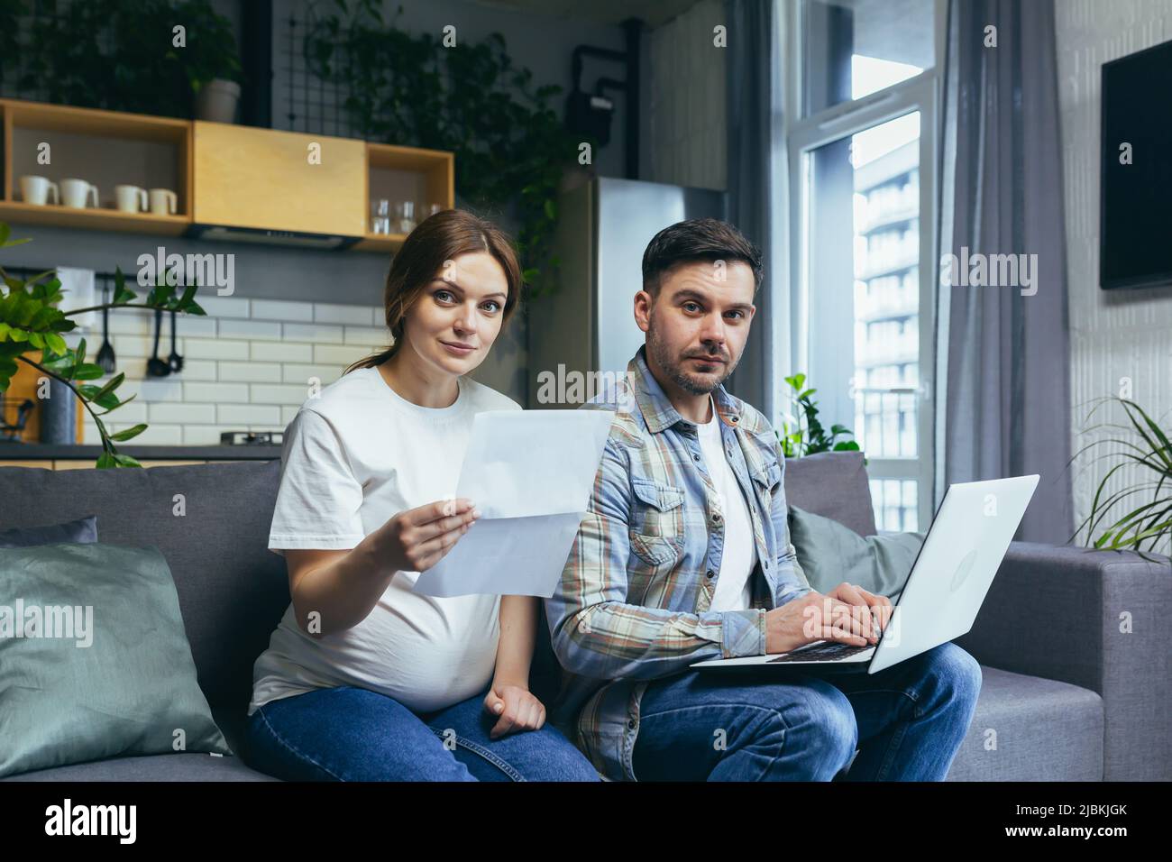 Young married couple, husband and pregnant wife together at home ...