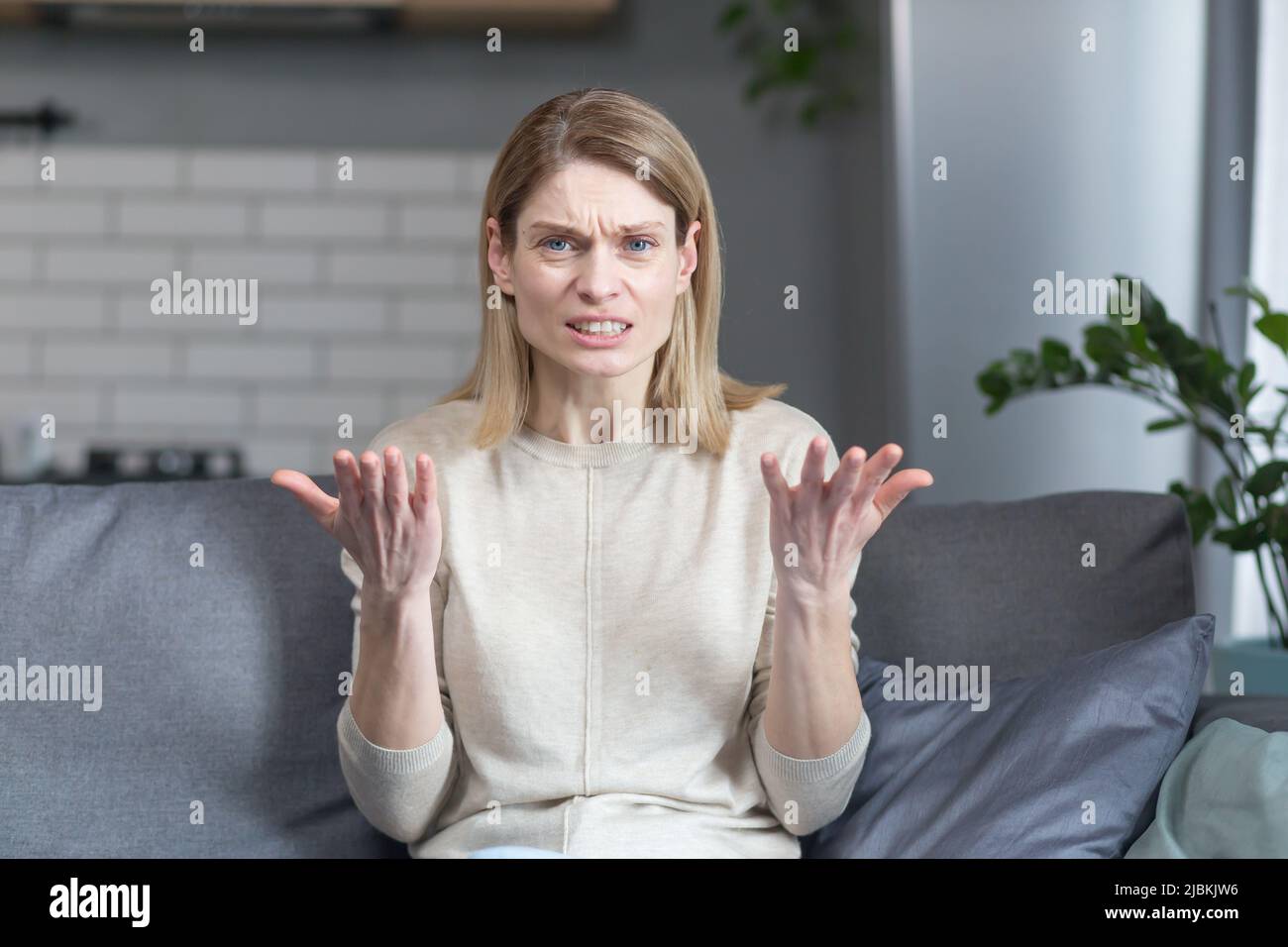 angry and frustrated woman talking on video call looking at webcam ...