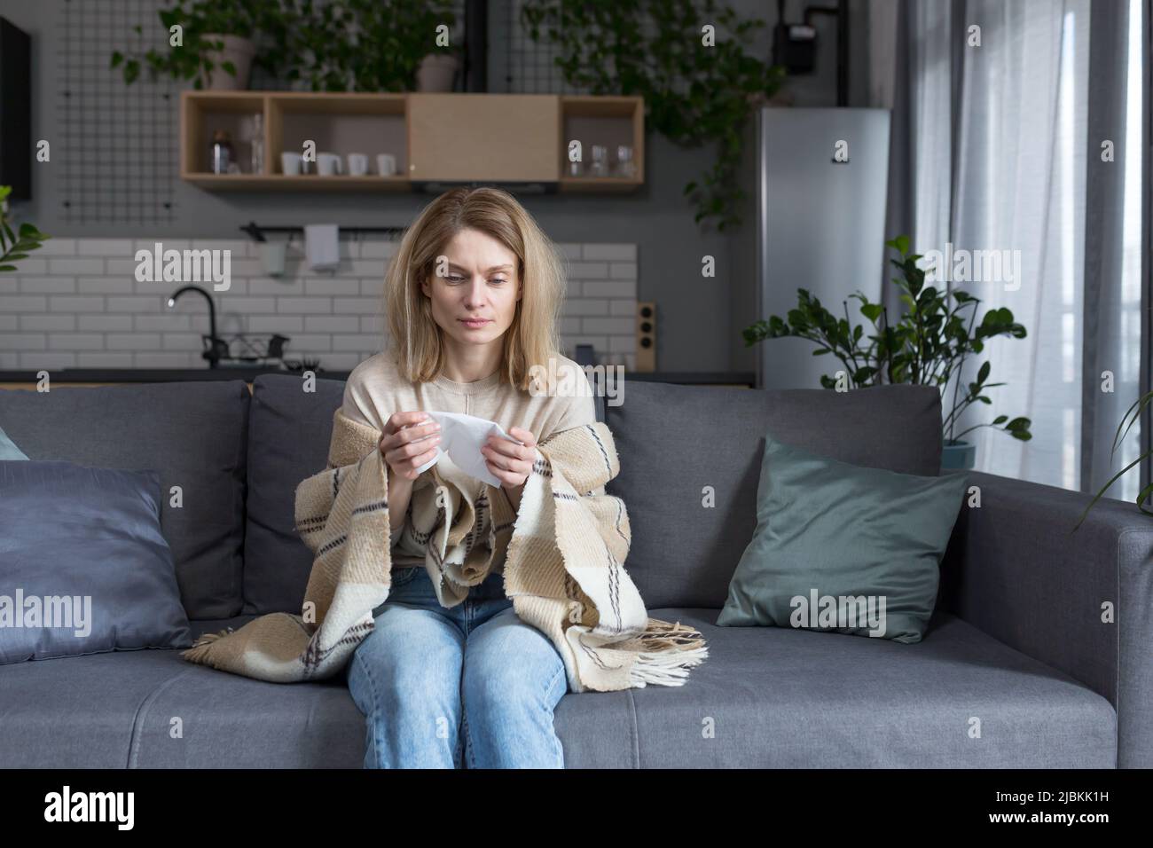 Sad woman at home sitting on sofa alone in depression crying Stock ...