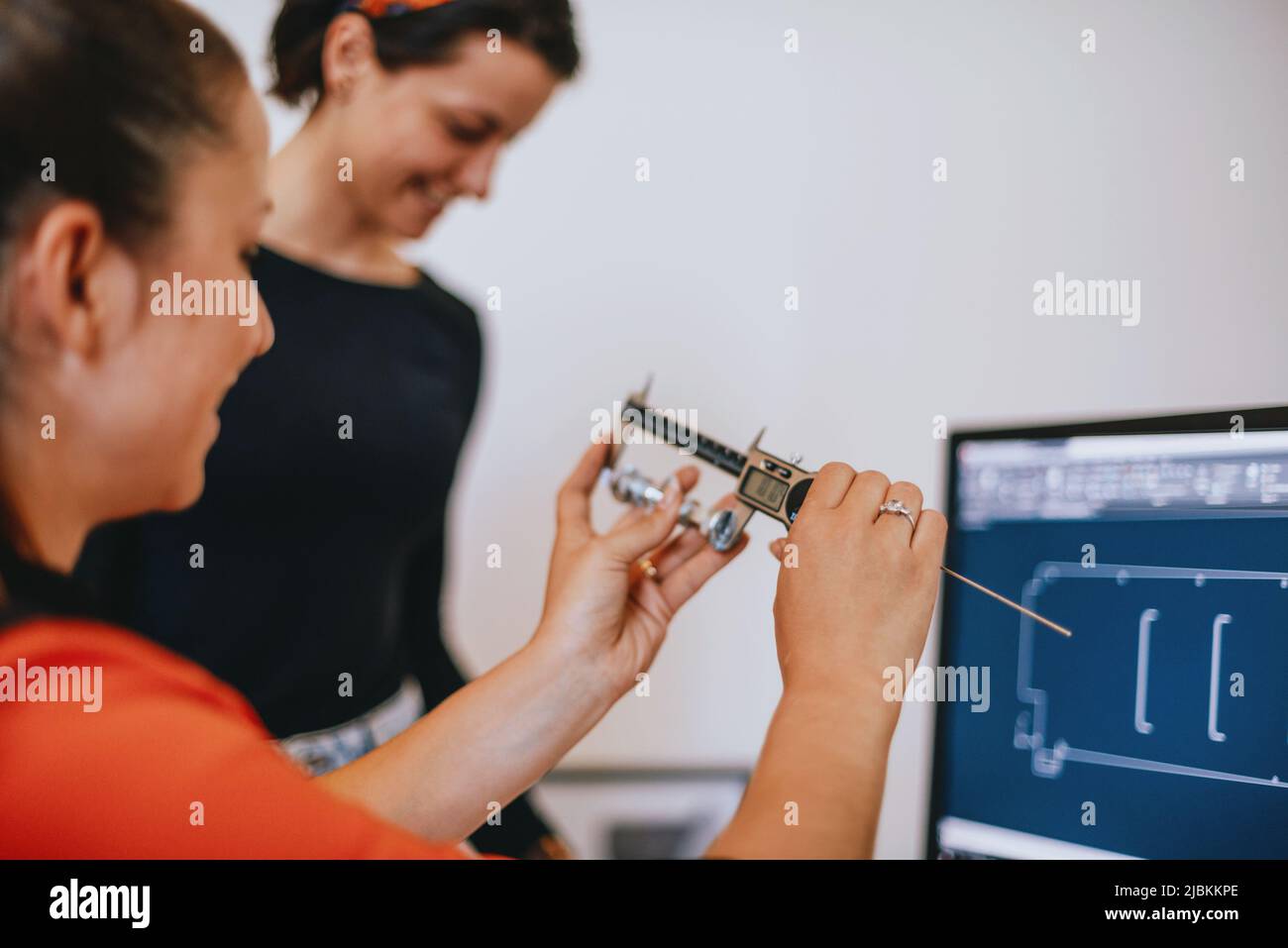 Within the heavy industry, a factory industrial engineer measures with a caliper and on a ...