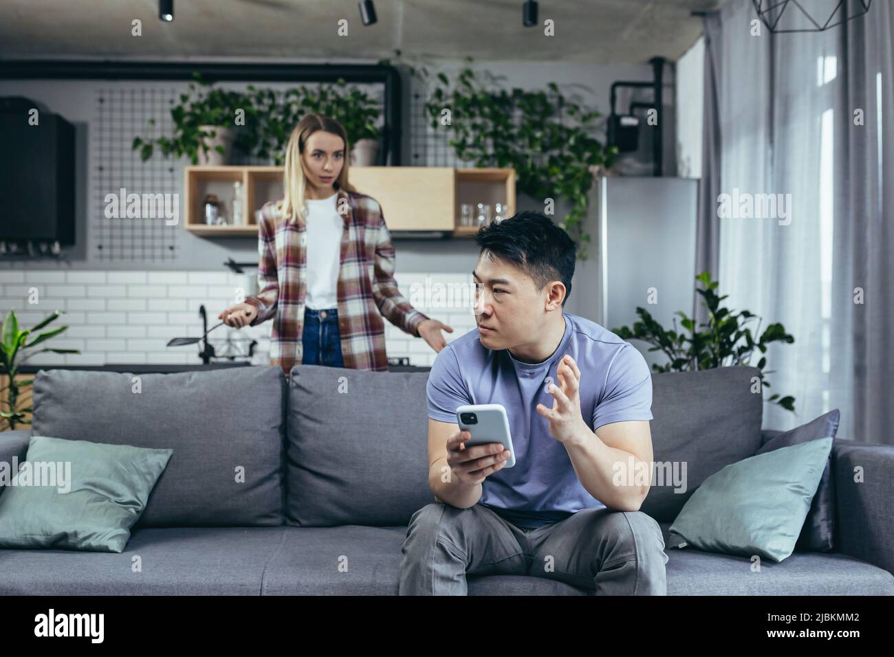 Couple quarreling at home, family crisis, Asian man corresponding on ...