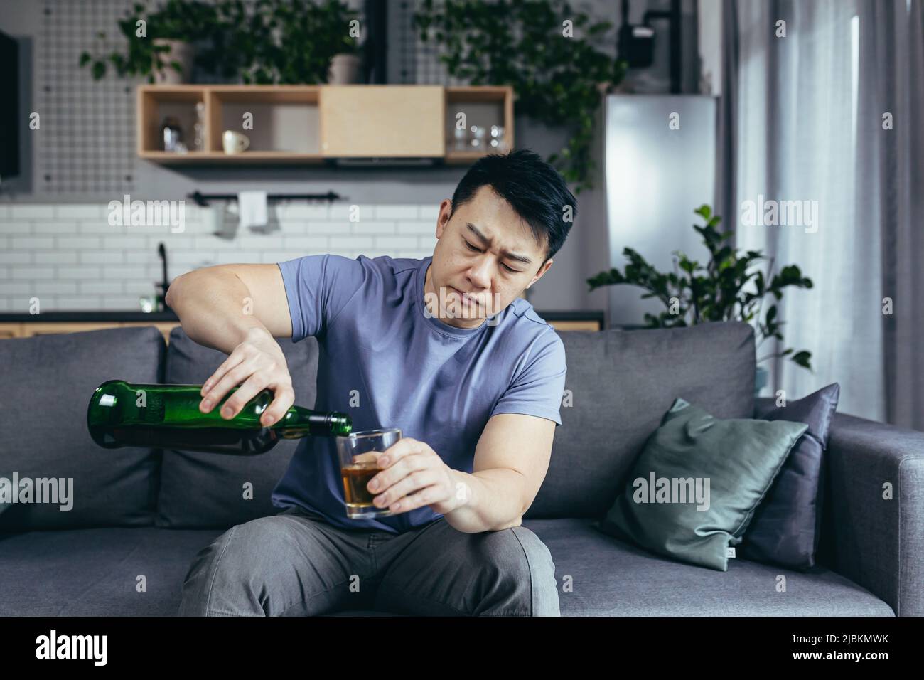 Asian man at home alone, depressed drinking strong alcohol, single man ...