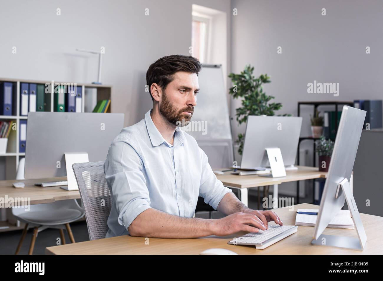 Concentrated and pensive businessman working in the office at the ...