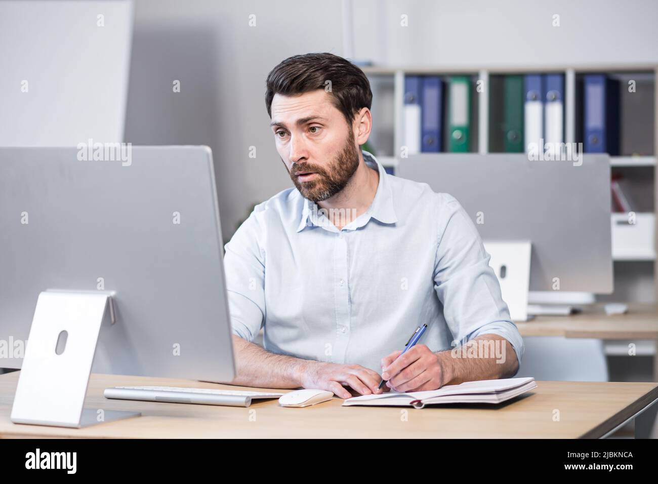 Concentrated and pensive businessman working in the office at the ...