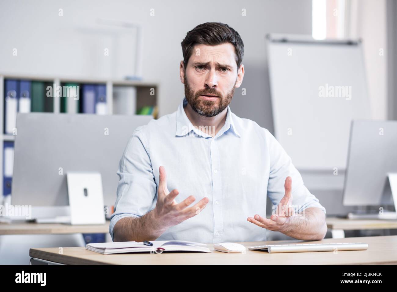 Angry and angry man looking at webcam talking on video call with ...