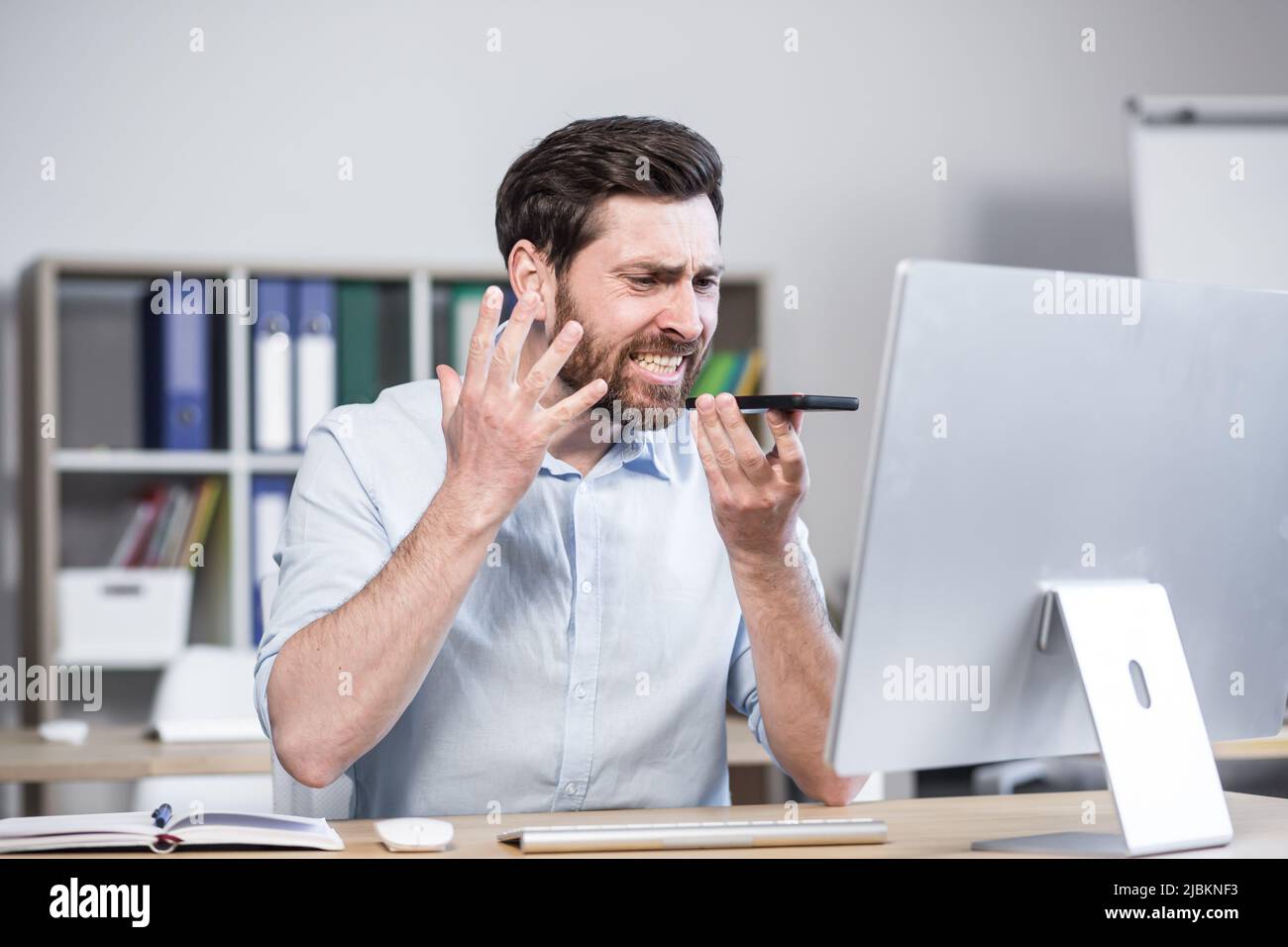 Aggressive man records voice message hi-res stock photography and ...