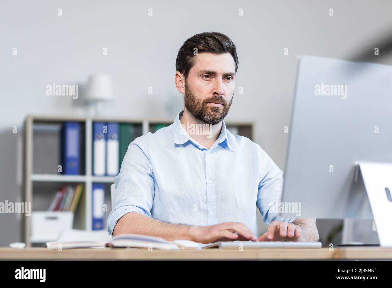 Portrait of a young man, focused and serious office worker, manager ...