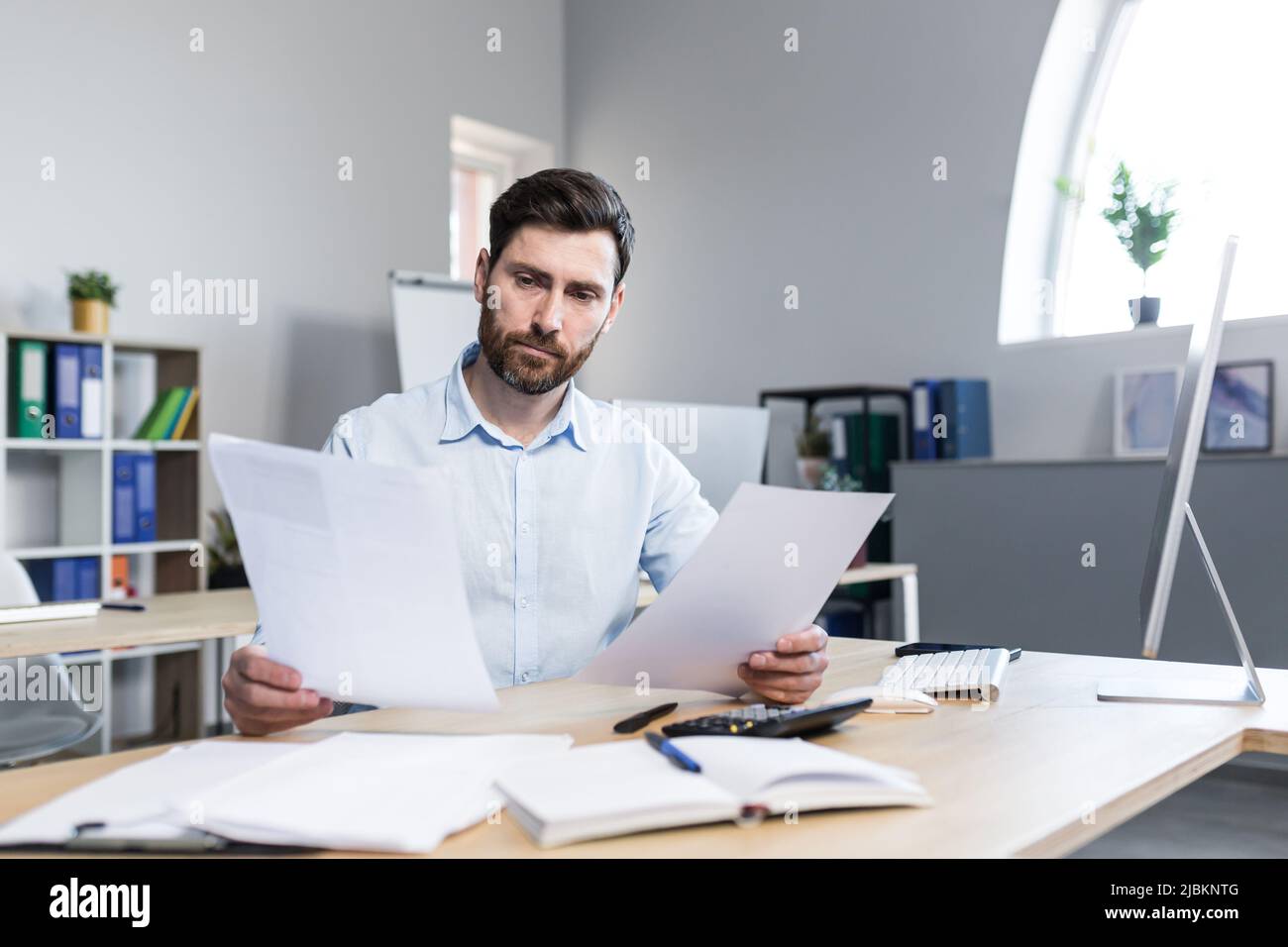 Confident business man stocks broker sitting in front of monitor screen ...