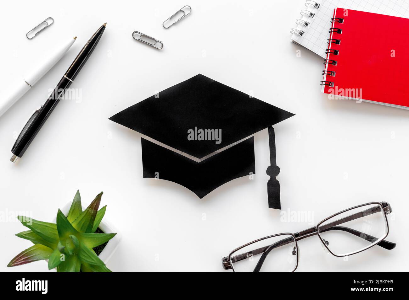 Black academic cap or graduation hat on students table, top view Stock ...
