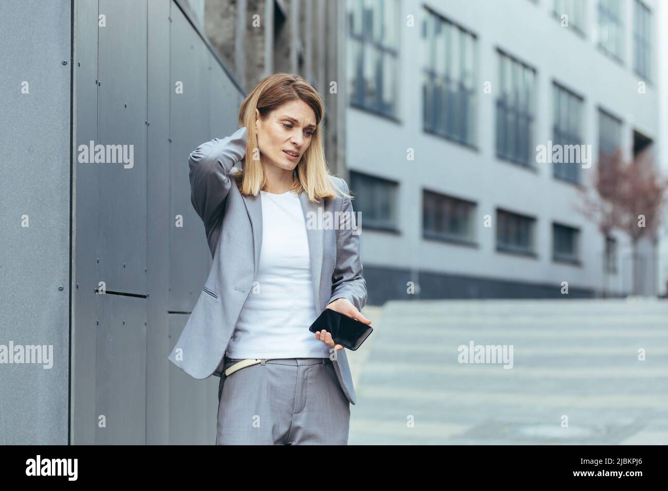 Woman near the office has severe back and neck pain, fatigue and ...