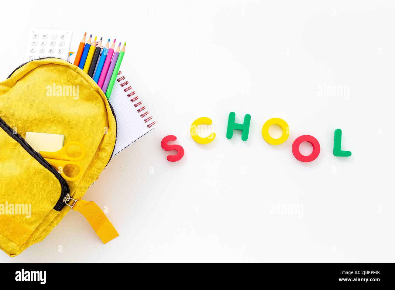 Yellow school backpack with colorful school stationery Stock Photo - Alamy