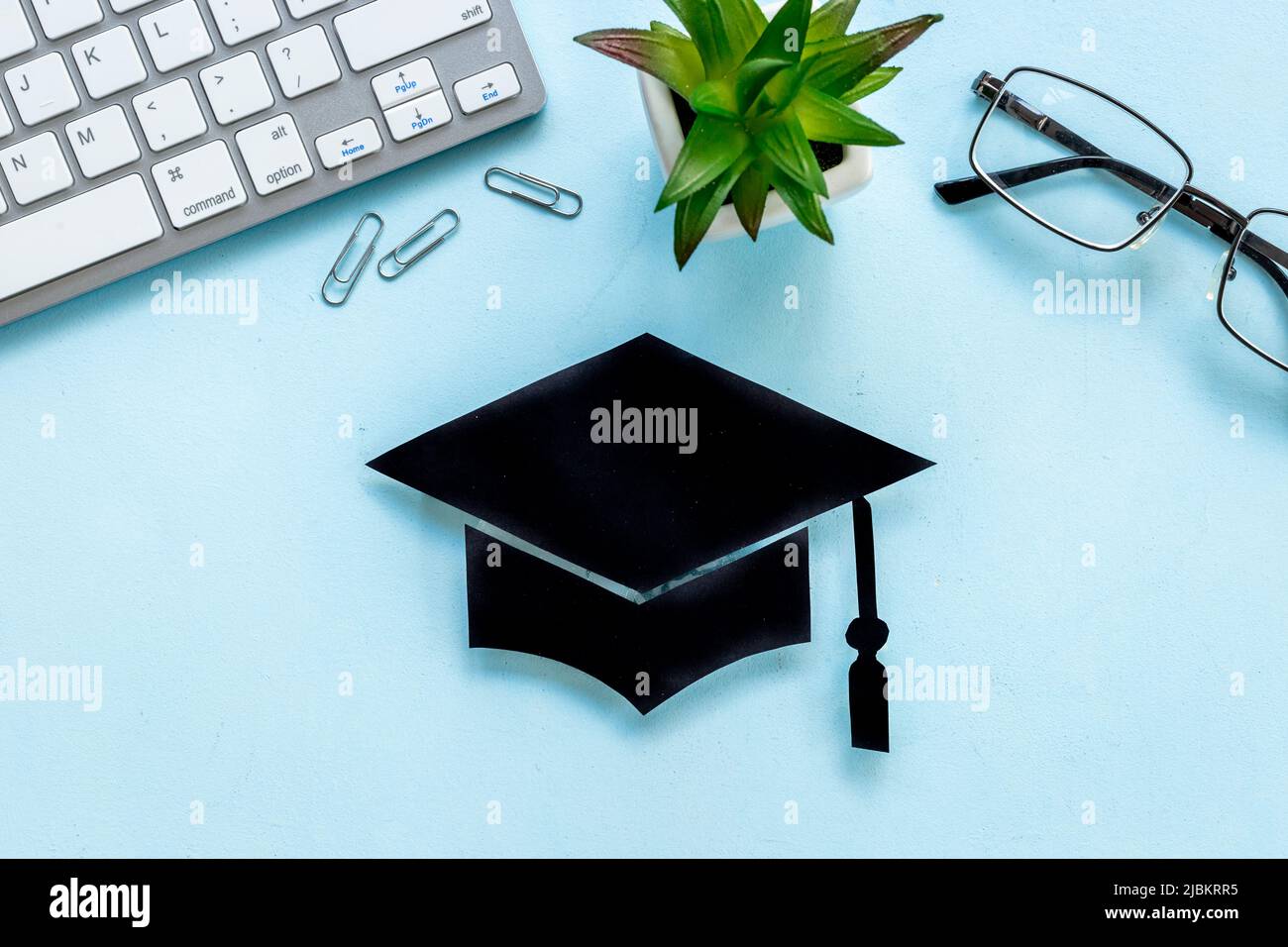 Education concept. Graduation hat on students table with supplies Stock ...