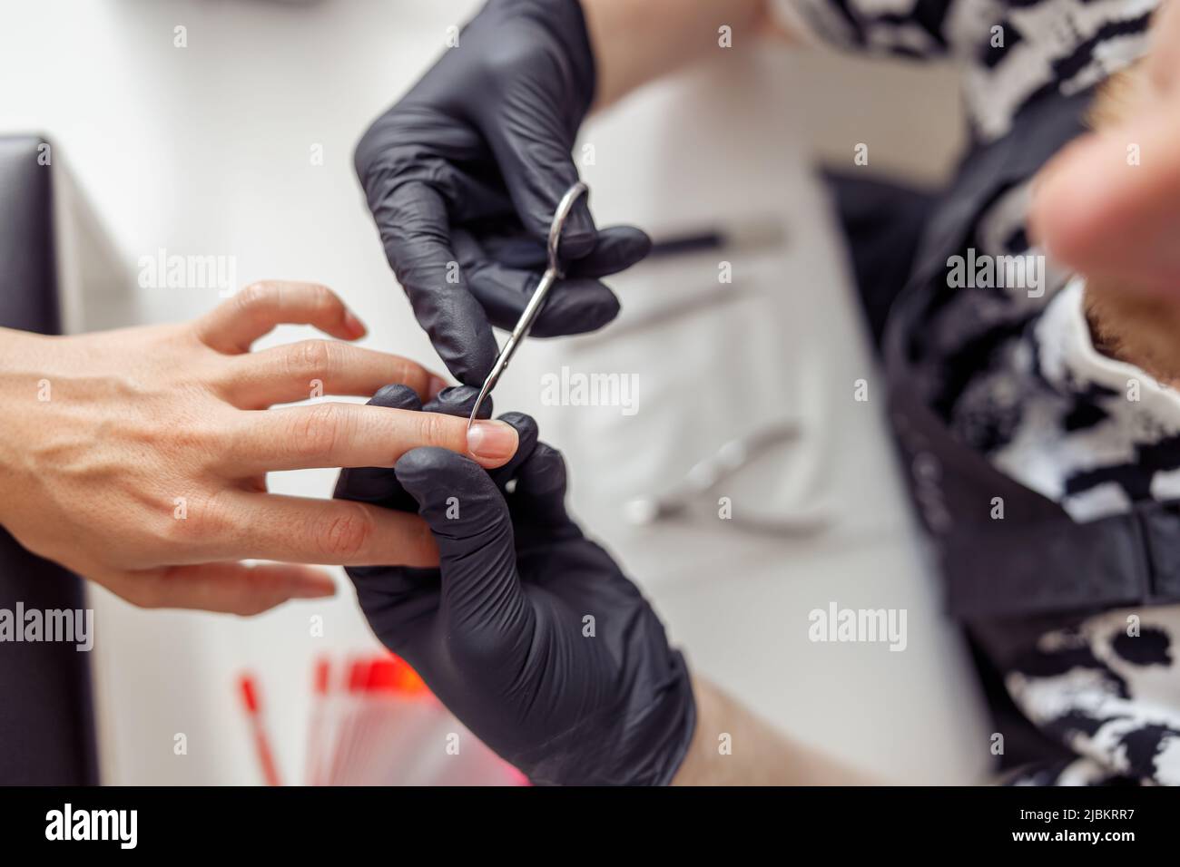Creative nail master processing nails of his client in salon Stock ...