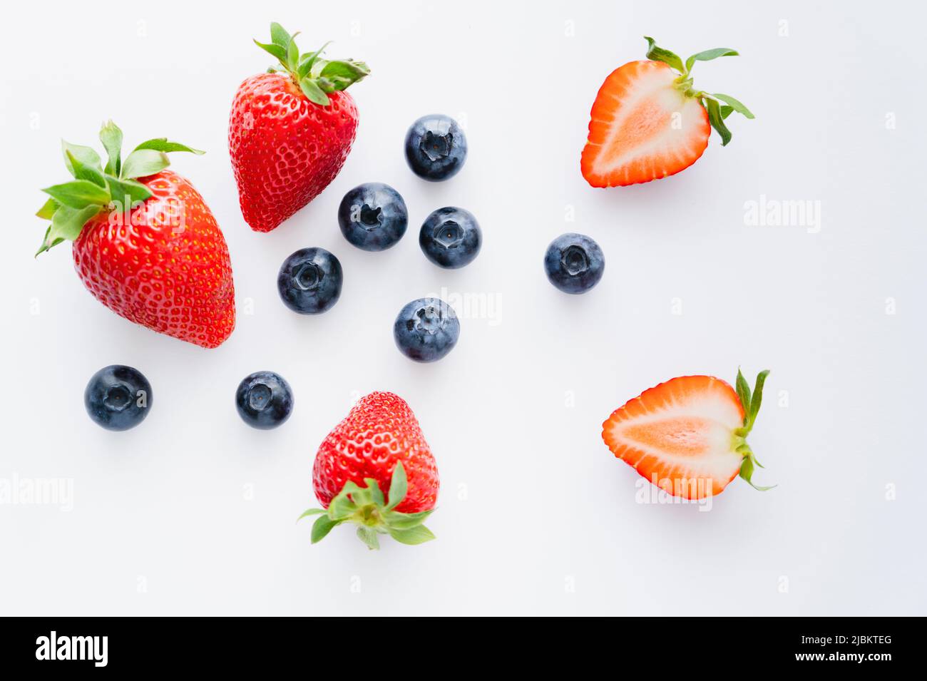 Top view of whole and cut berries on white background Stock Photo - Alamy