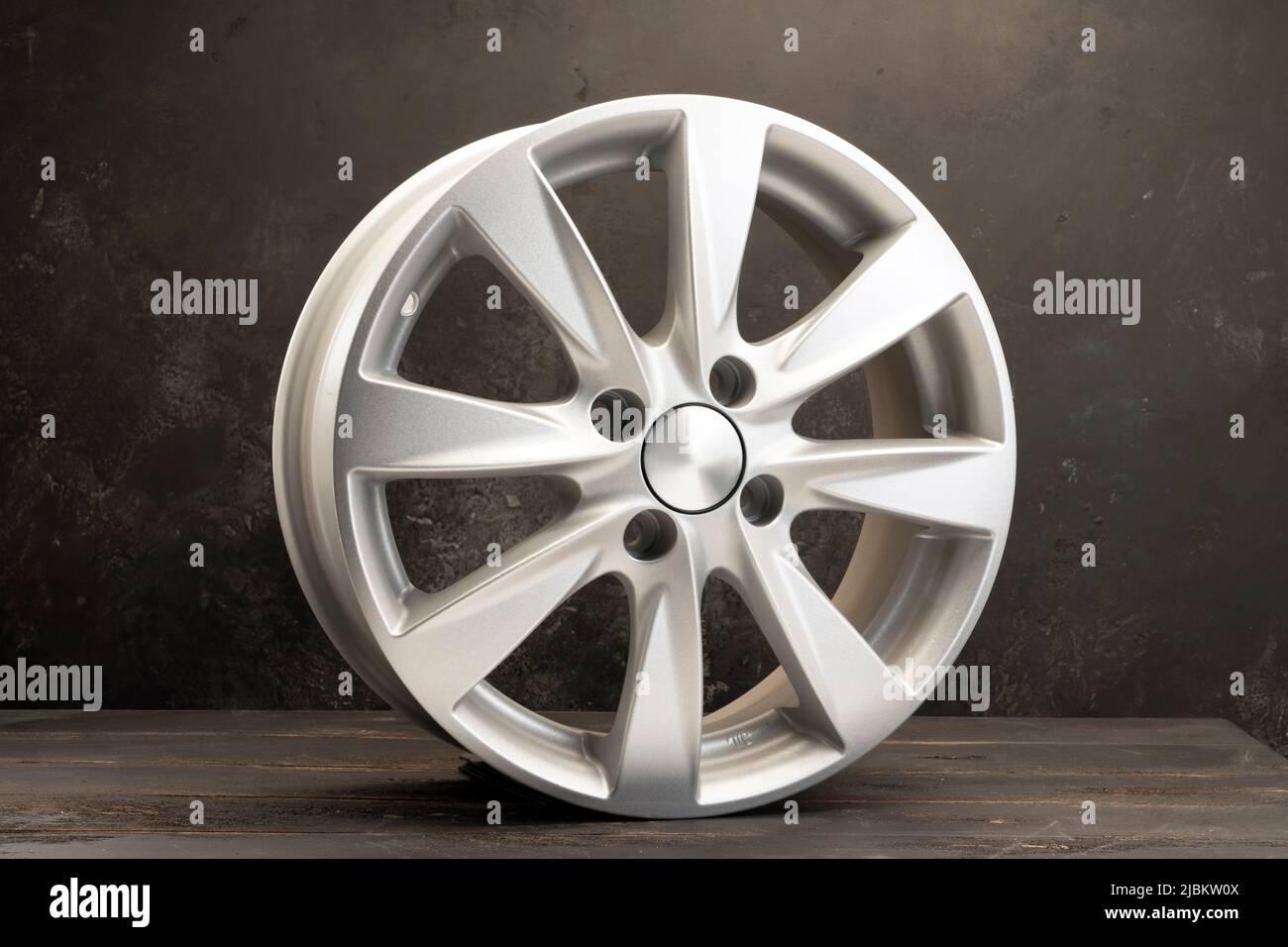 new grey alloy wheels on a dark textured black background. a wheel for ...