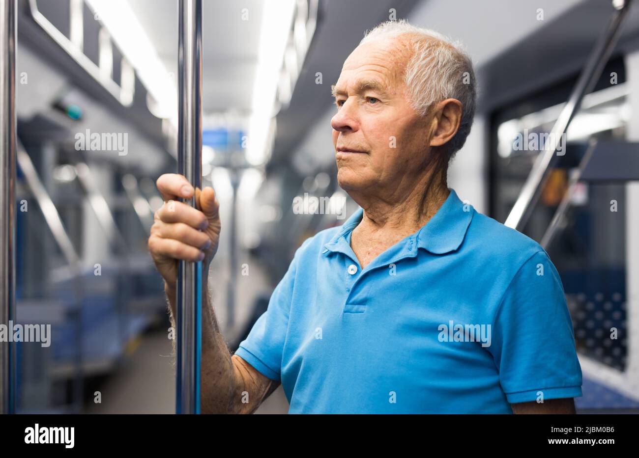 Old man standing in subway car Stock Photo - Alamy