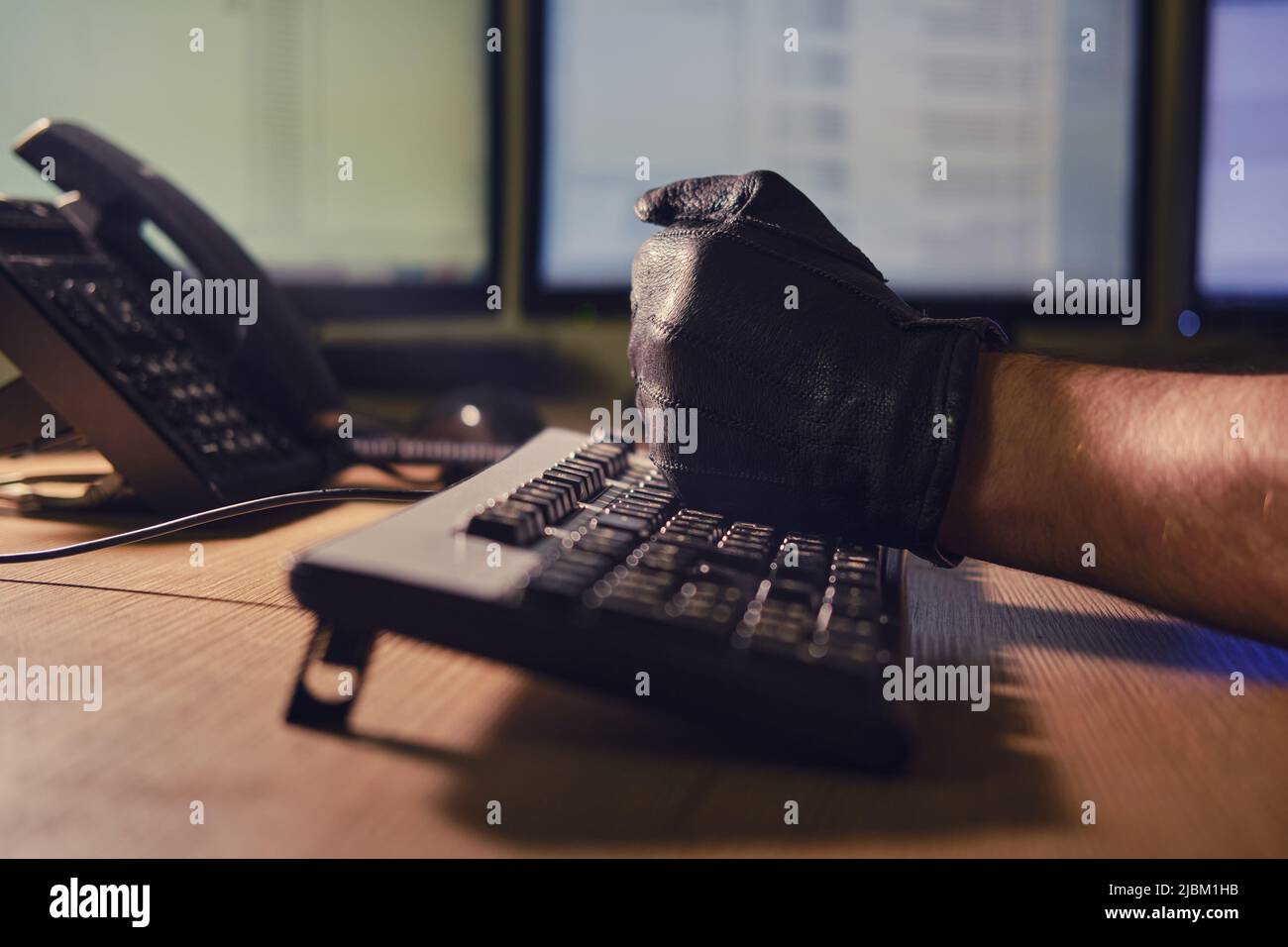Angry man hacker in black gloves on his hands working on a computer ...
