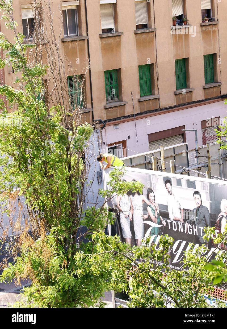 Man placing advertising poster on an advertising billboard in Barcelona ...