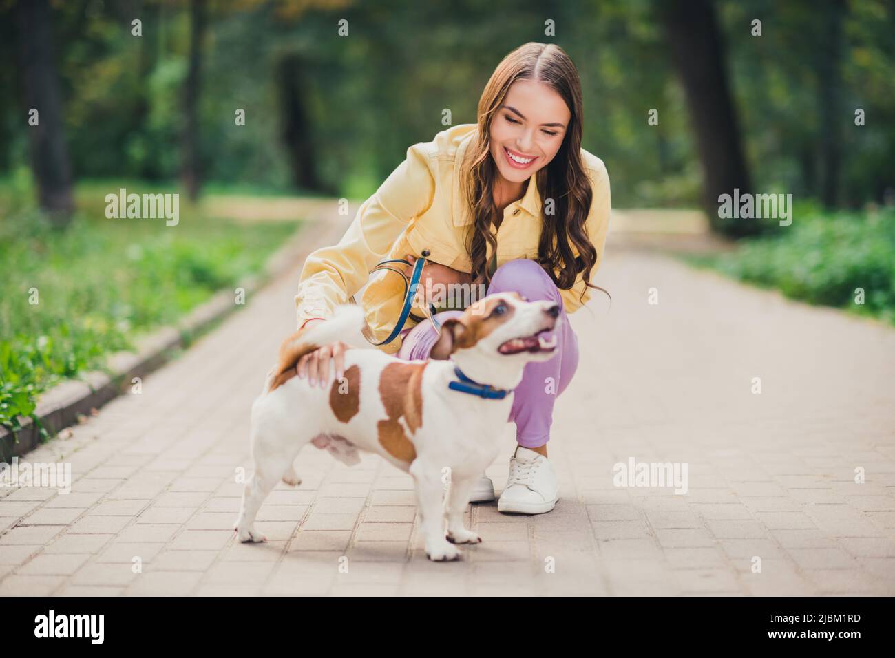Portrait of attractive cheerful girl cuddling dog having fun spending ...