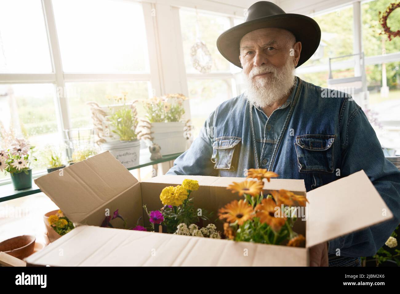 Aged florist packing flowers ito box for sale Stock Photo - Alamy