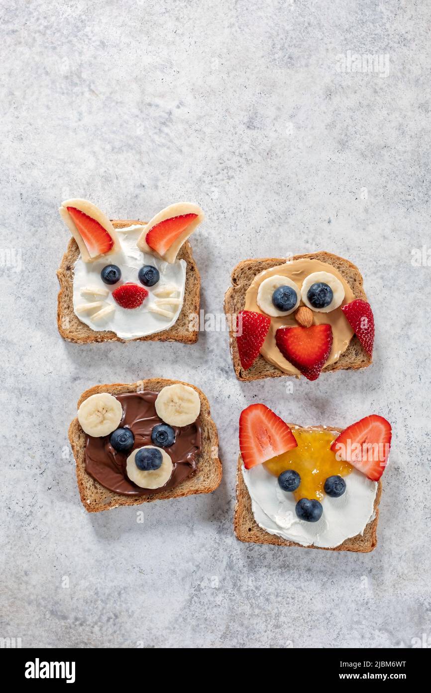 Funny animal faces toasts with spreads, butters, banana, strawberry and ...