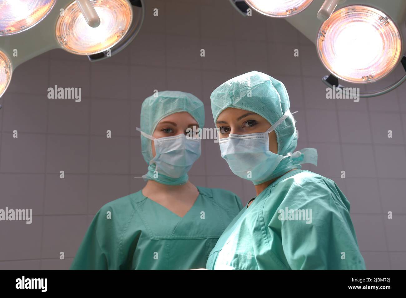 Two young women are seen in an operation theater dressed with medical ...