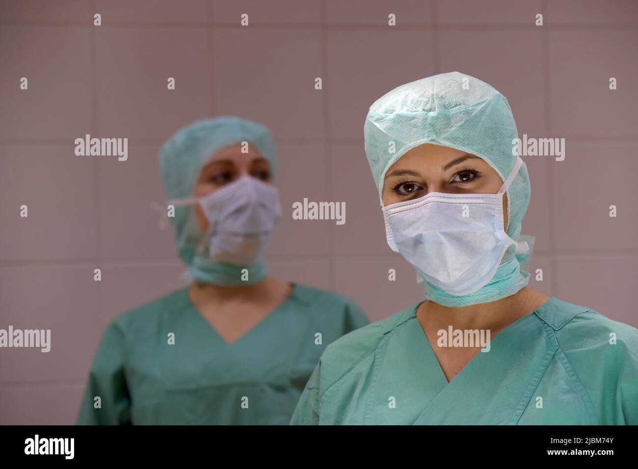 Two young women are seen in an operation theater dressed with medical ...
