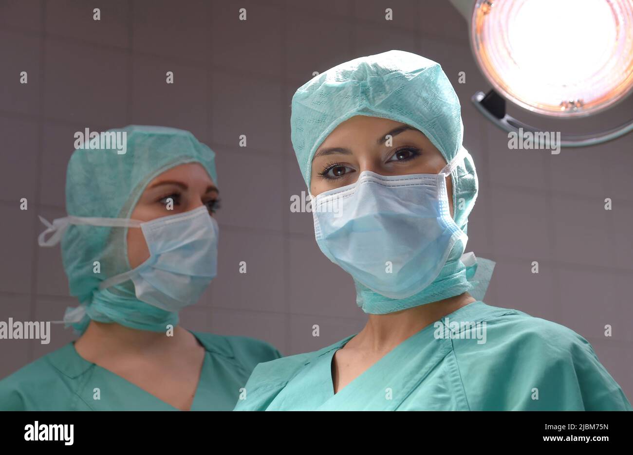 Two young women are seen in an operation theater dressed with medical ...
