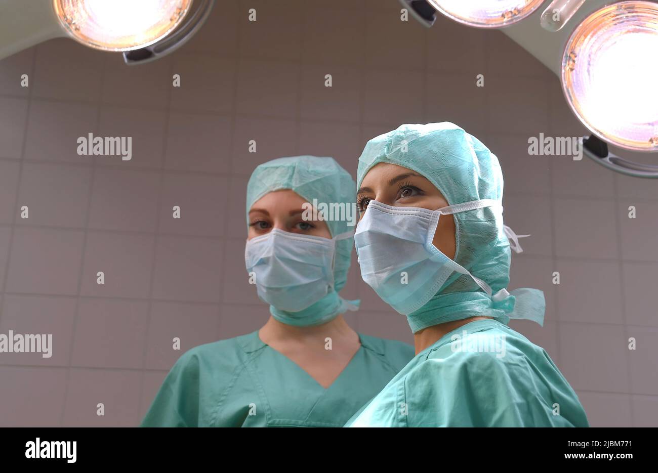 Two young women are seen in an operation theater dressed with medical ...