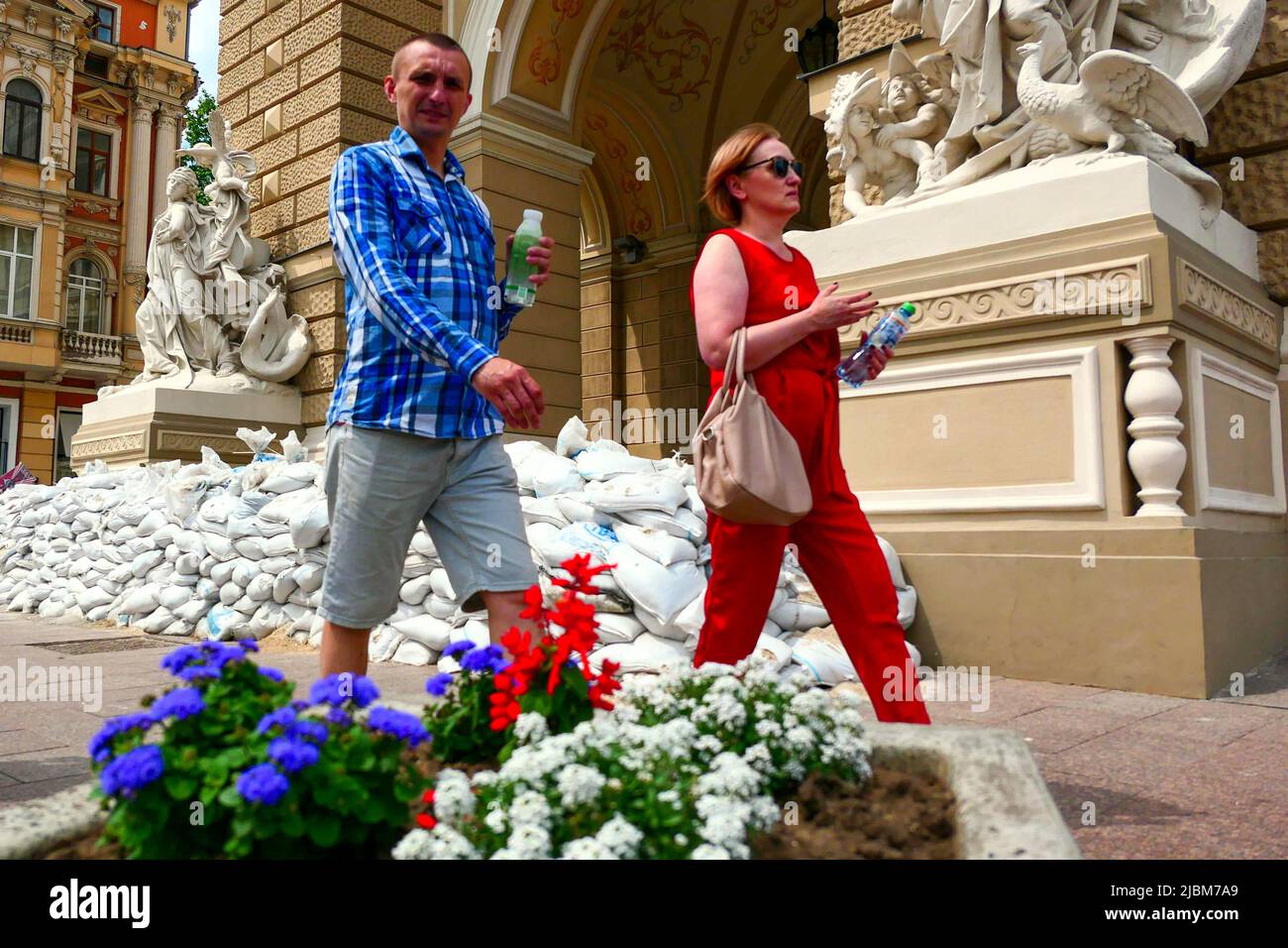 ODESA, UKRAINE - JUNE 5, 2022 - A man and a woman walk past a barricade ...