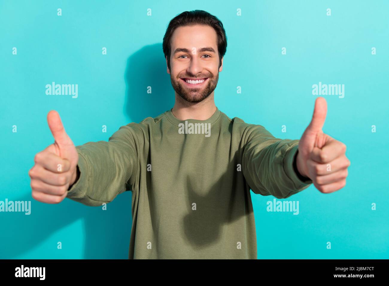 Photo of funky brunet millennial guy thumb up wear green shirt isolated ...